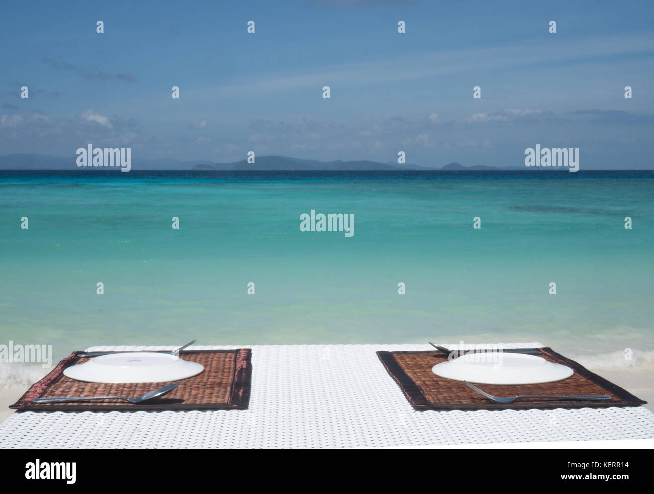 Table setting at the beach restaurant with beautiful blue sea and sky ...