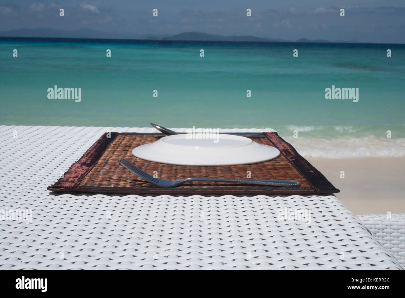 Table setting at the beach restaurant with beautiful blue sea and sky ...