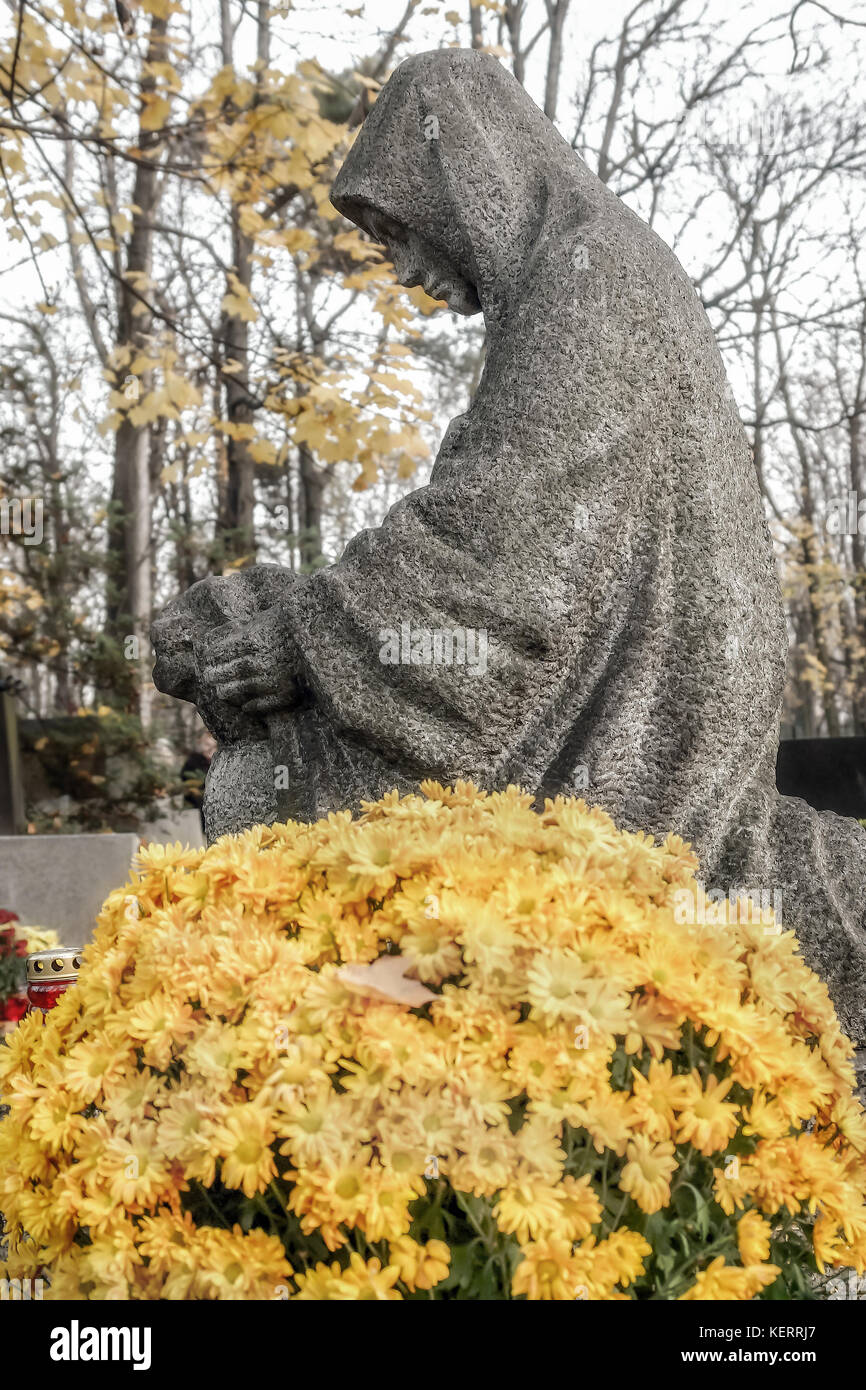 Stone mourning statue sitting on tombstone Stock Photo - Alamy
