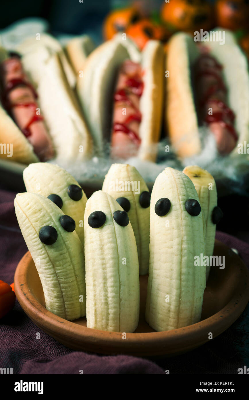 closeup of some funny halloween food, such as bananas with eyes as ...