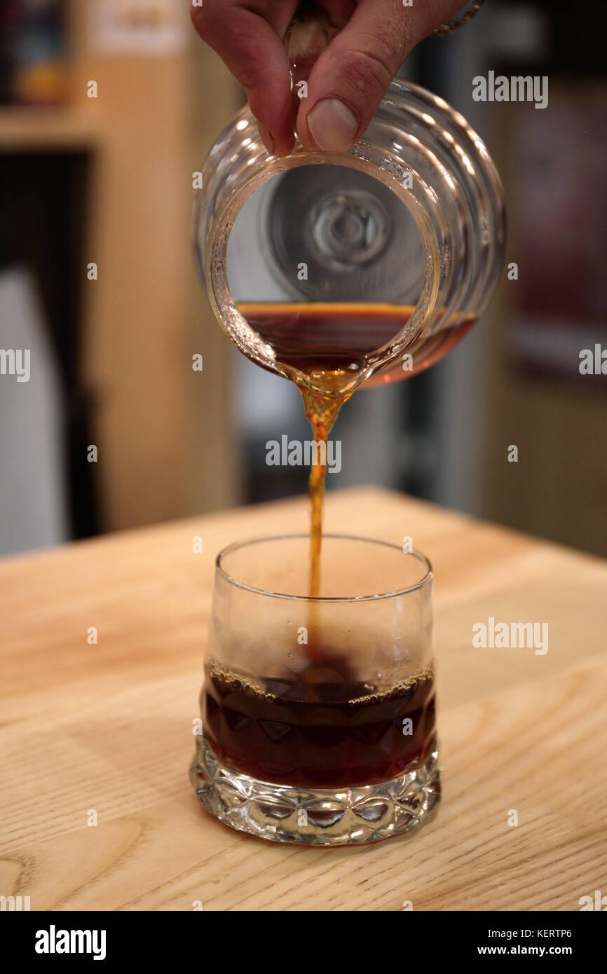 Barista pours a coffin into the glass cup serves a drink. Kemex Stock ...