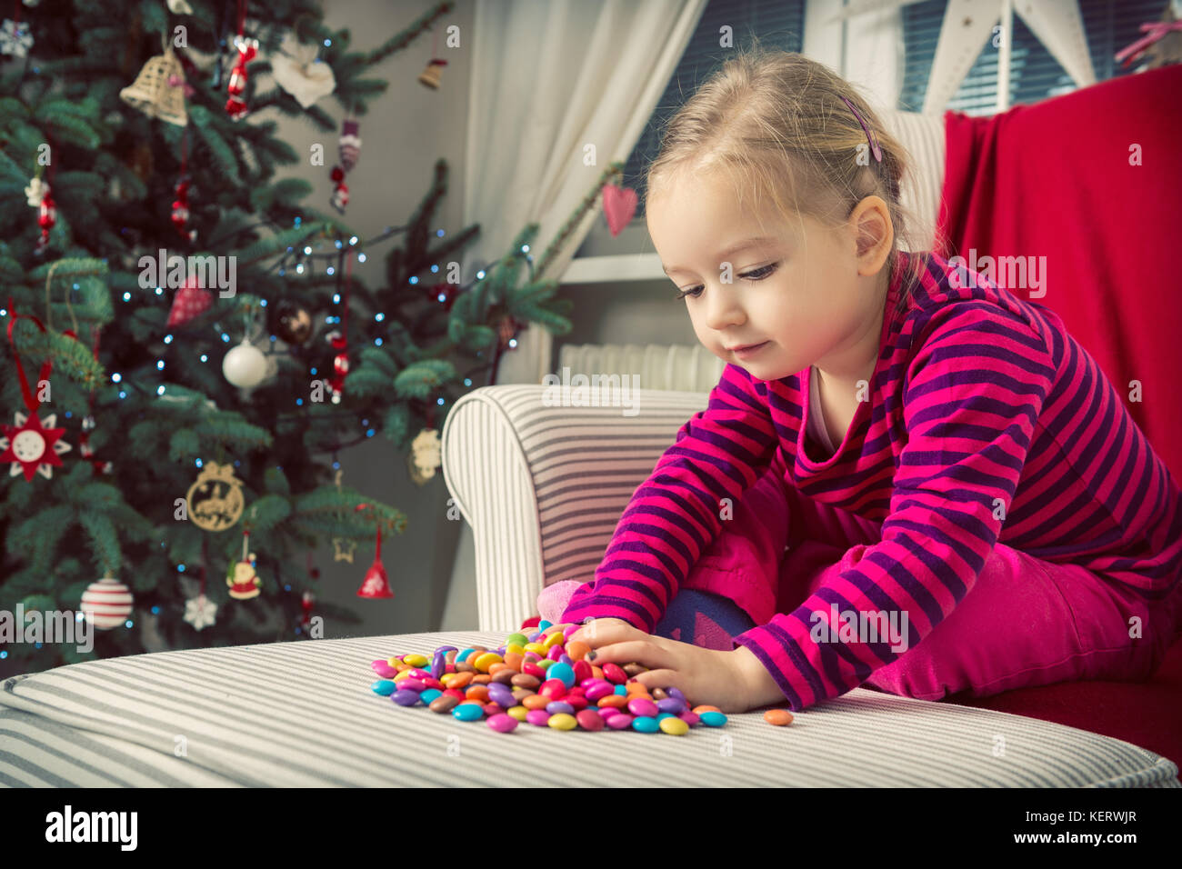 Adorable preschool girl playing with sweets on xmas eve Stock Photo - Alamy