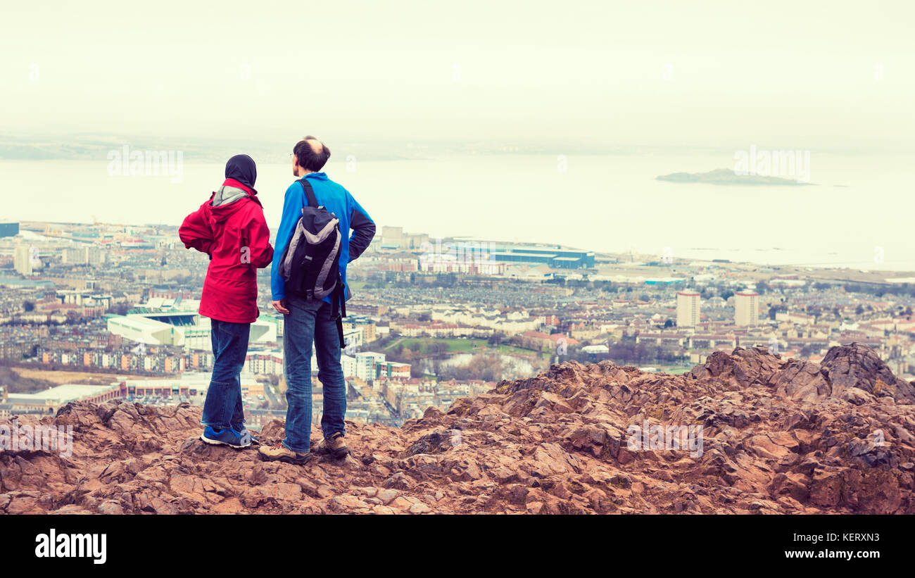 Tourists enjoying view of Edinburgh from top of Arthurs seat, ancient ...