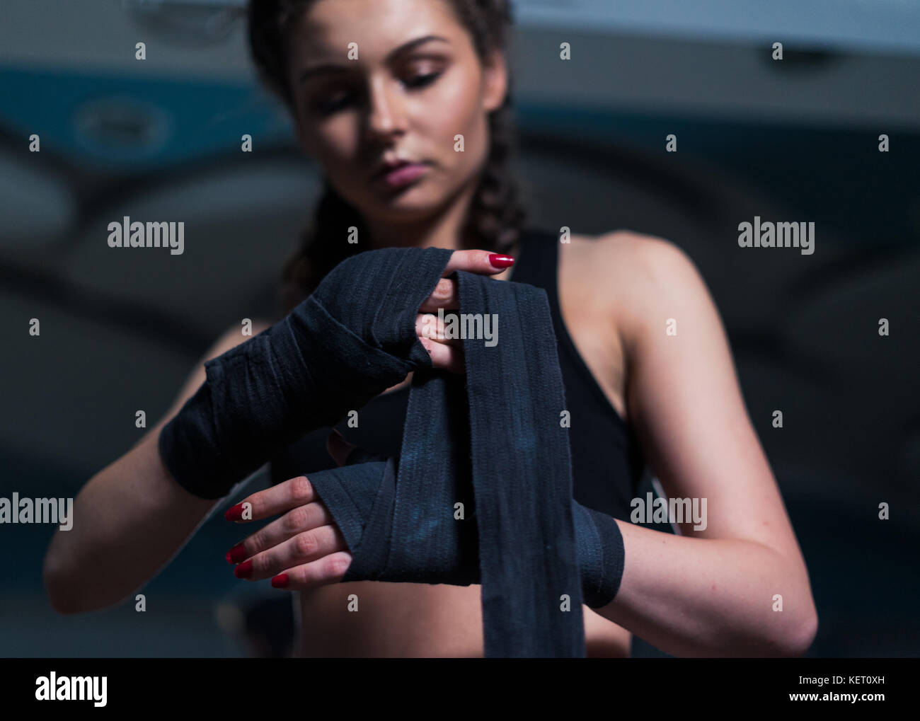 Young fighter boxer girl putting on hand bandage before training Stock ...