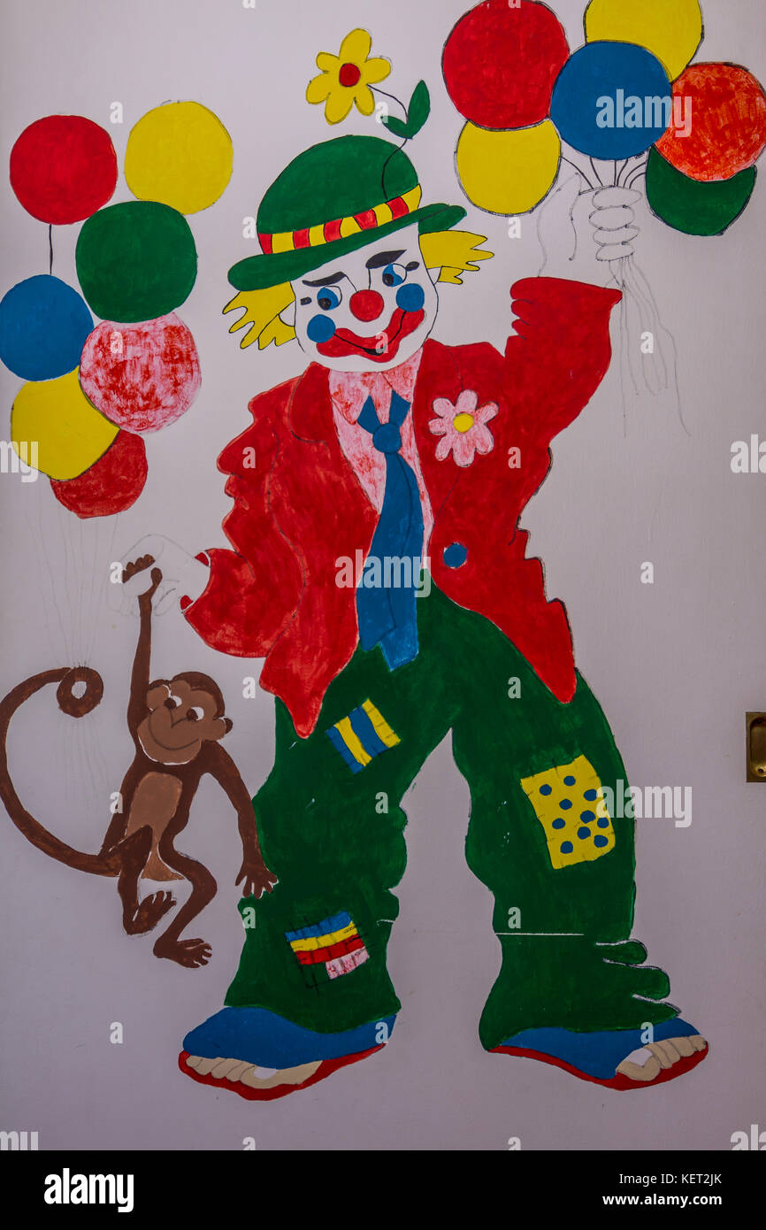 Painting of a clown, monkey, and balloons on the door of a child's room ...