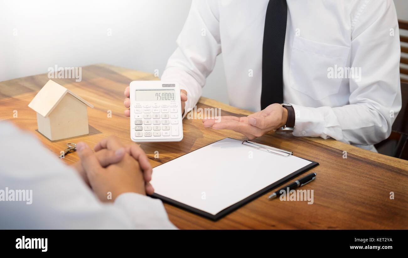 Real estate agent showing the purchase price on a calculator to ...