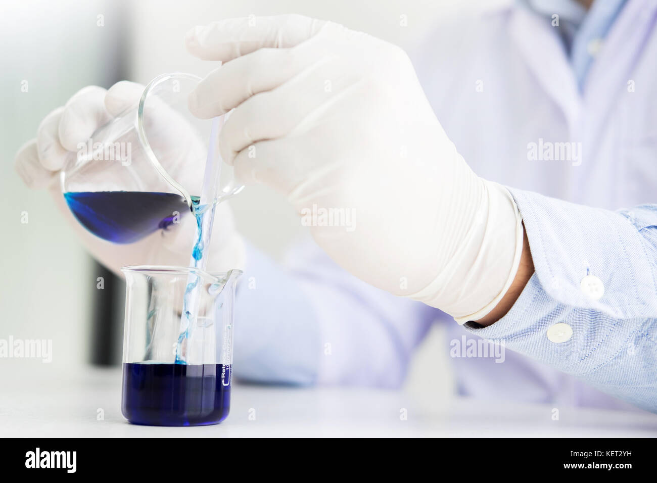 scientists and scientific equipment Pouring mixing reagents liqiud ...