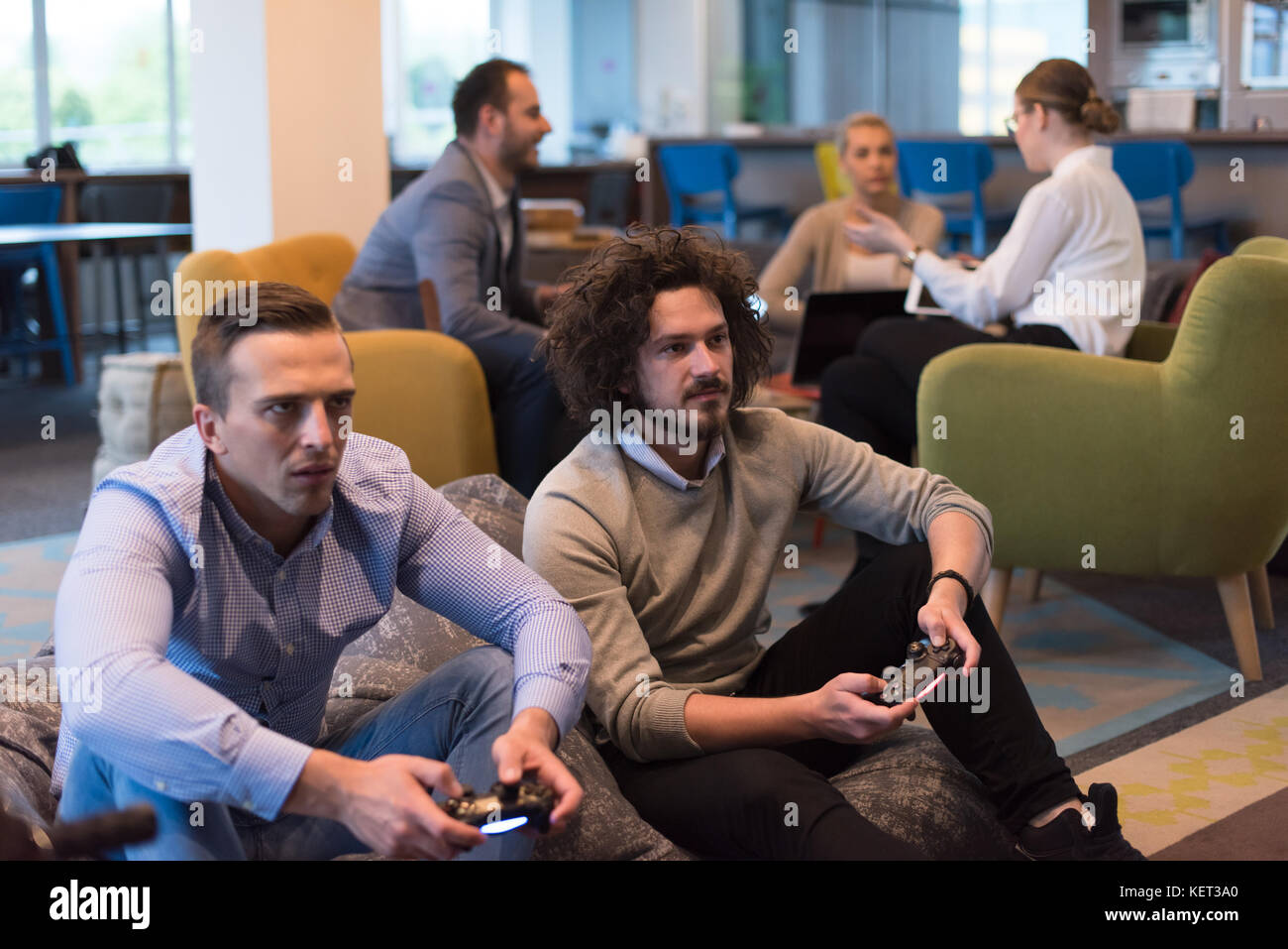 Work hard play hard. Workers Playing computer games in creative startup ...