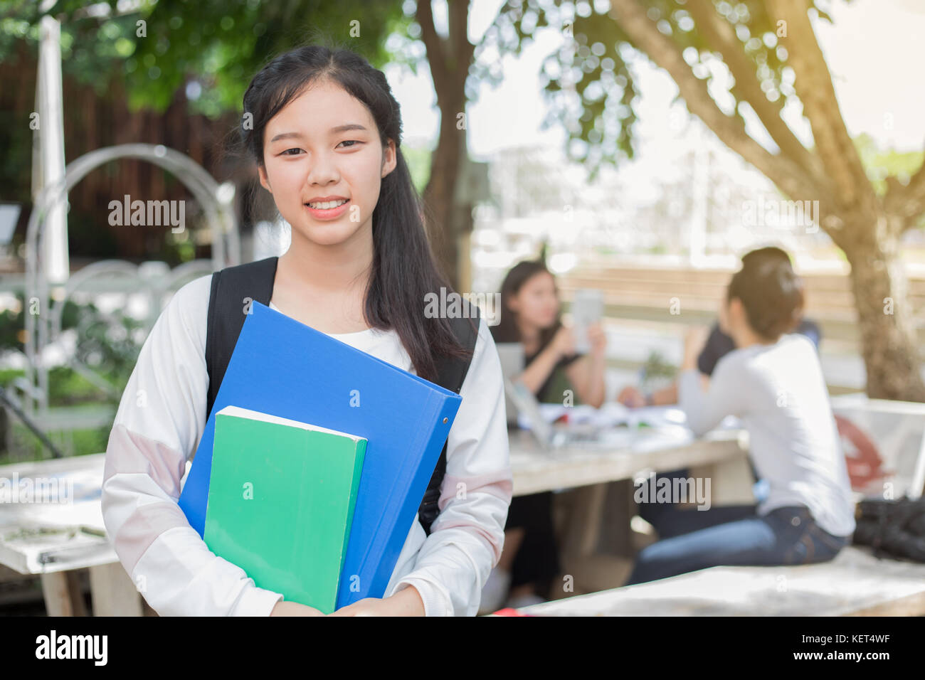 Asian student girl holding book on campus Stock Photo - Alamy