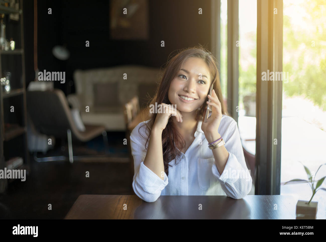 woman asian calling with cell telephone while sitting alone in coffee ...