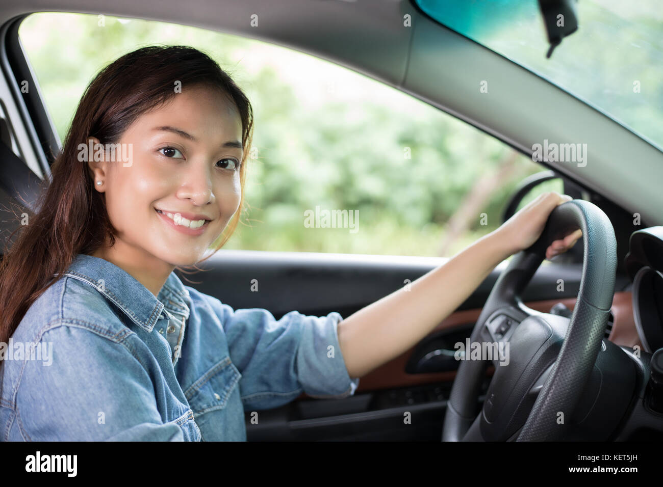 Beautiful Asian woman smiling and enjoying.driving a car on road for ...