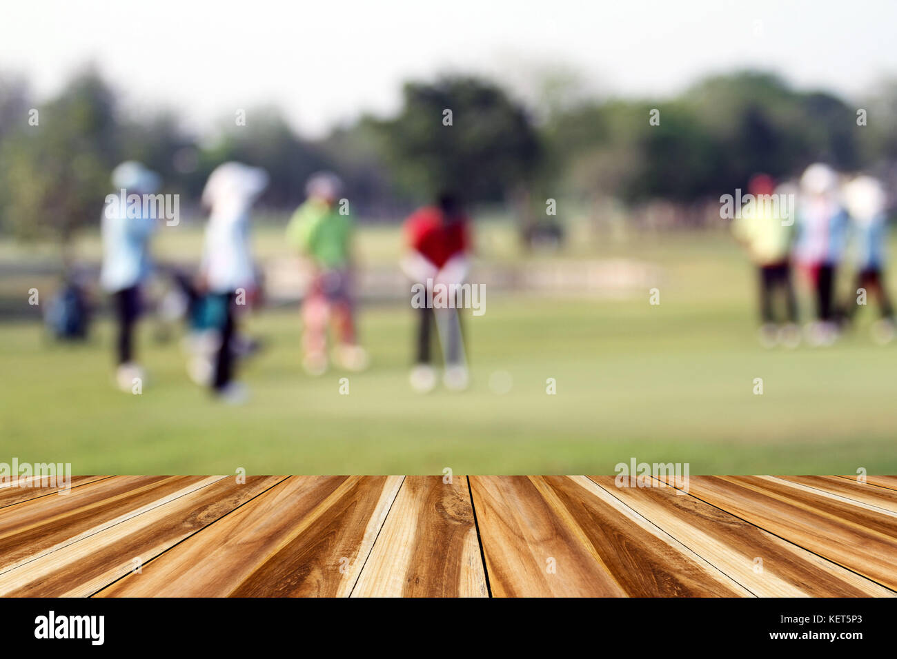 perspective wood and blurred golfers hit sweeping and keep golf course ...