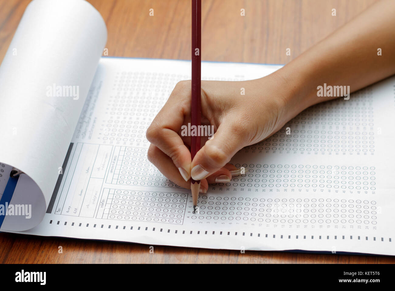 hand of women holding pencil on Standardized test form with answers ...