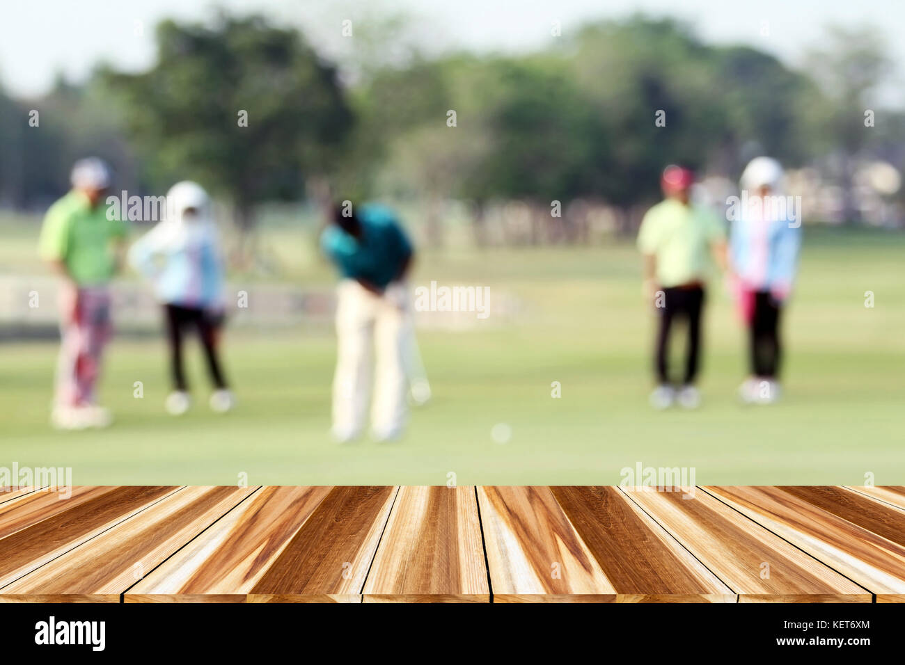 perspective wood and blurred golfers hit sweeping and keep golf course ...