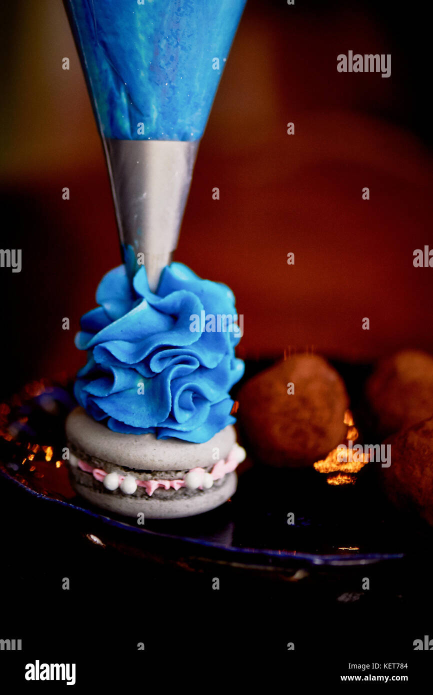application of blue butter cream with a cooking bag in grey macaron ...