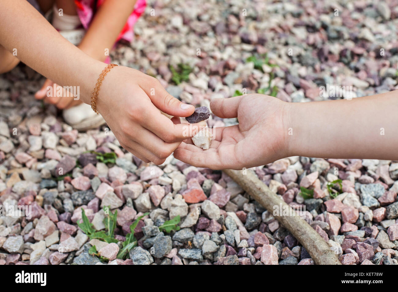 Little girl giving stones Stock Photo - Alamy