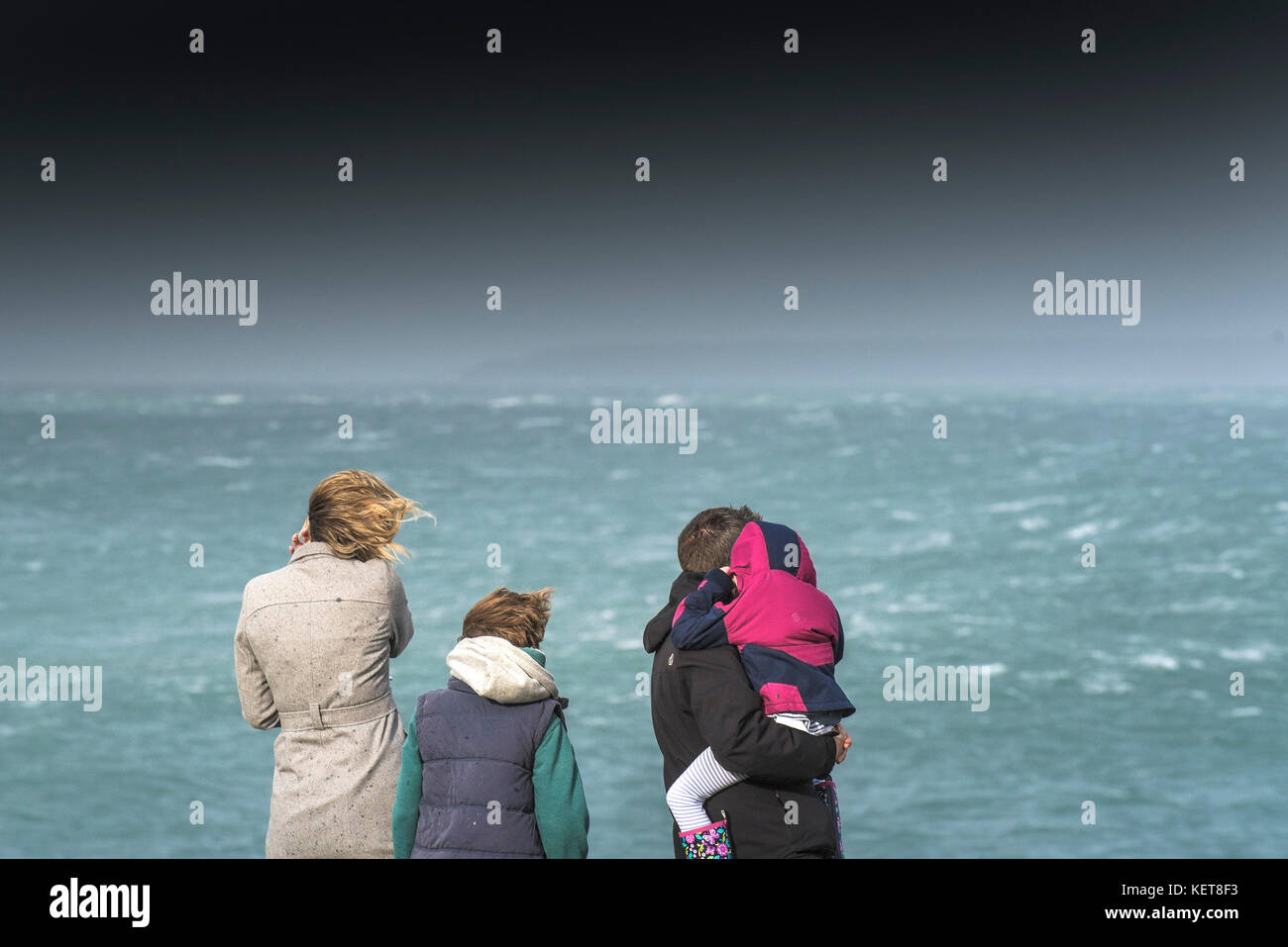 UK Weather Storm Ophelia - a family watching the stormy sea conditions ...