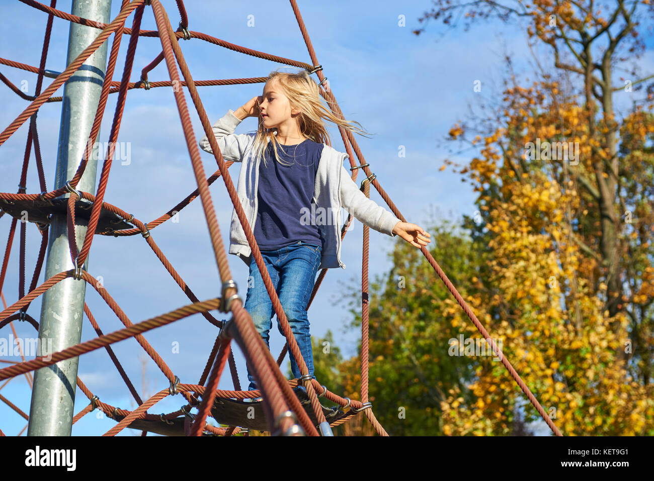 Active young child girl climbing the spider web playground activity ...