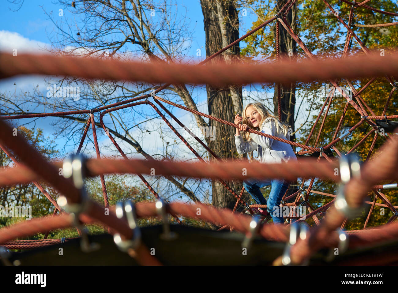 Active young child girl climbing the spider web playground activity ...