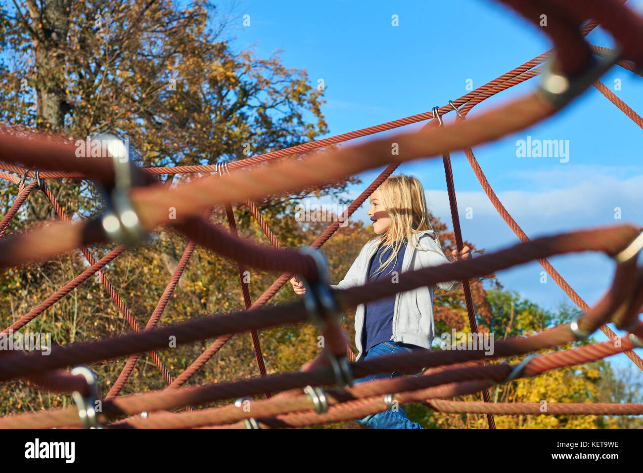 Active young child girl climbing the spider web playground activity ...