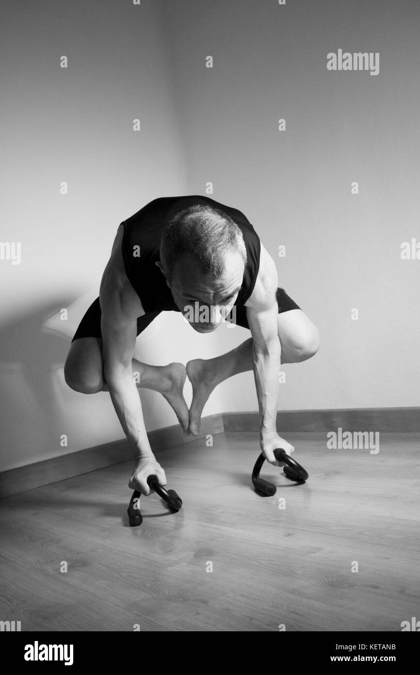 Man performing crow motion in yoga Stock Photo - Alamy