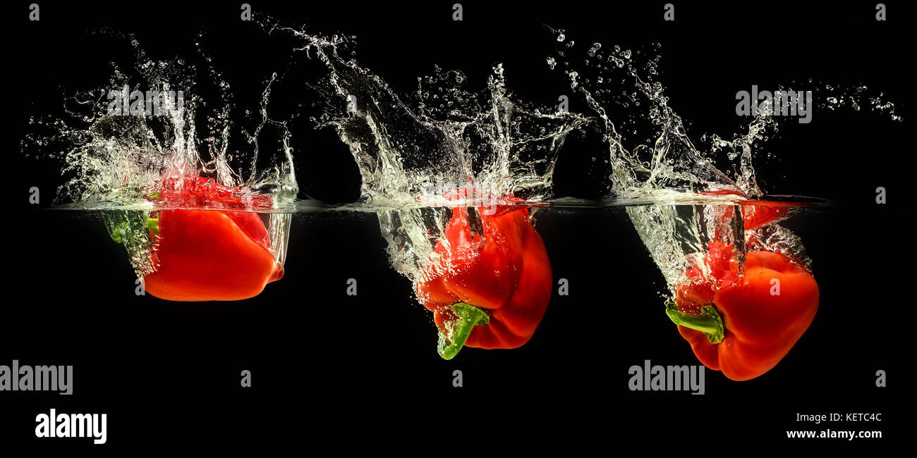 Red bell pepper falling in water Stock Photo - Alamy