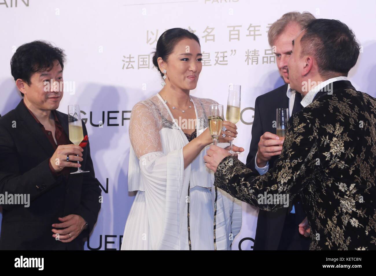 Chinese actress Gong Li (white dress) attends a promotional event for ...