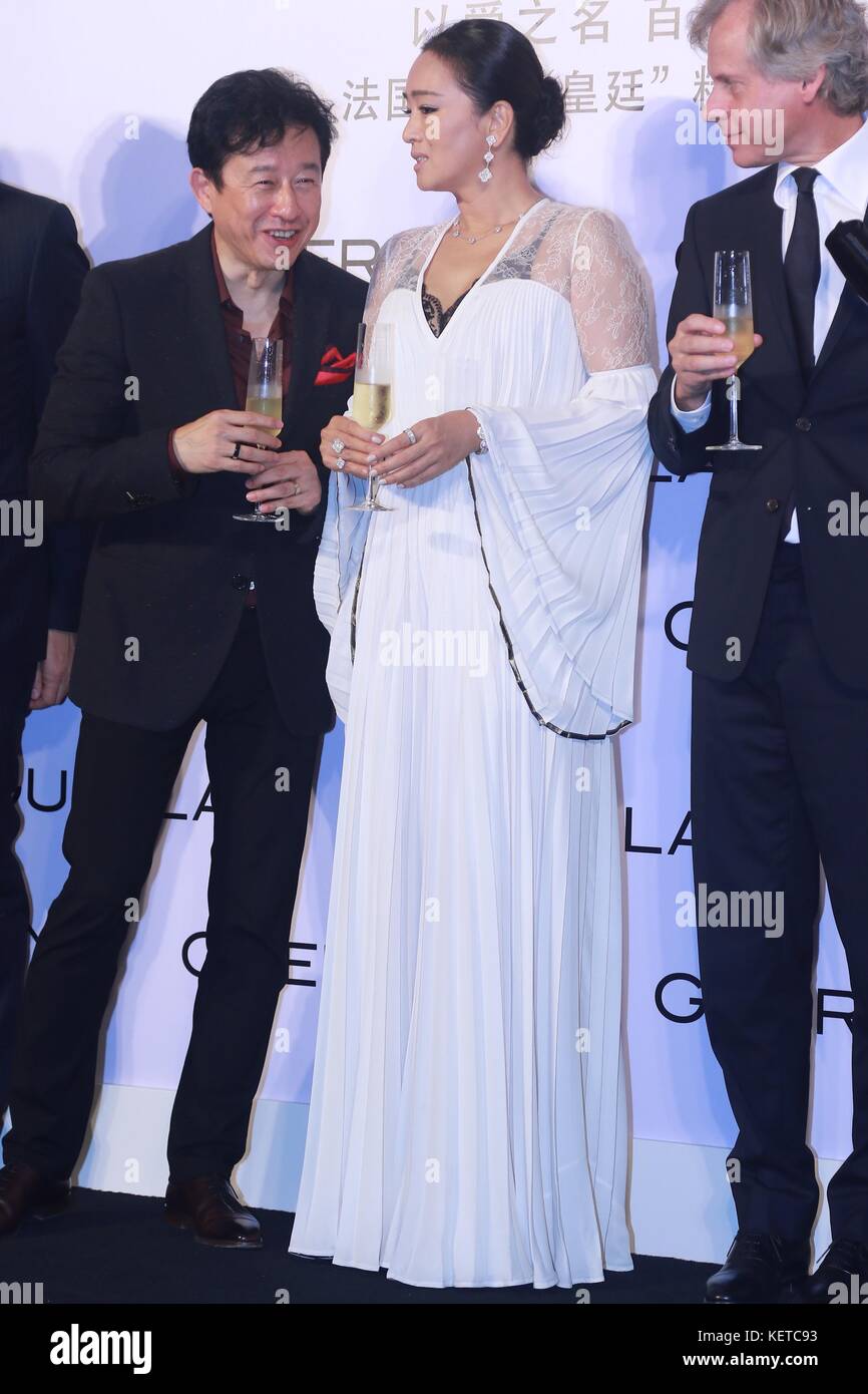 Chinese actress Gong Li (white dress) attends a promotional event for ...