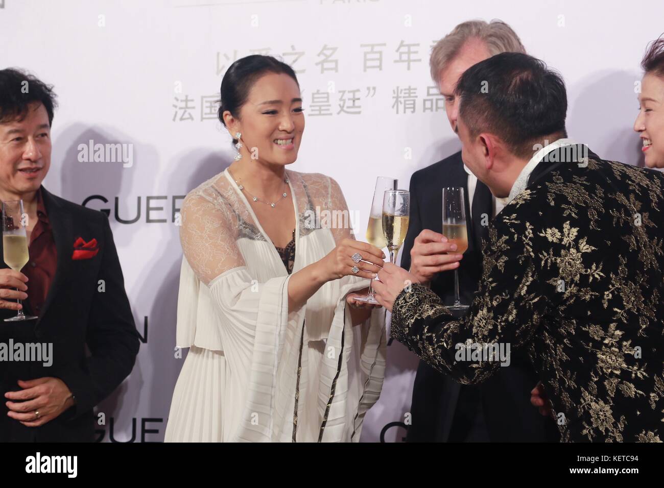 Chinese actress Gong Li (white dress) attends a promotional event for ...