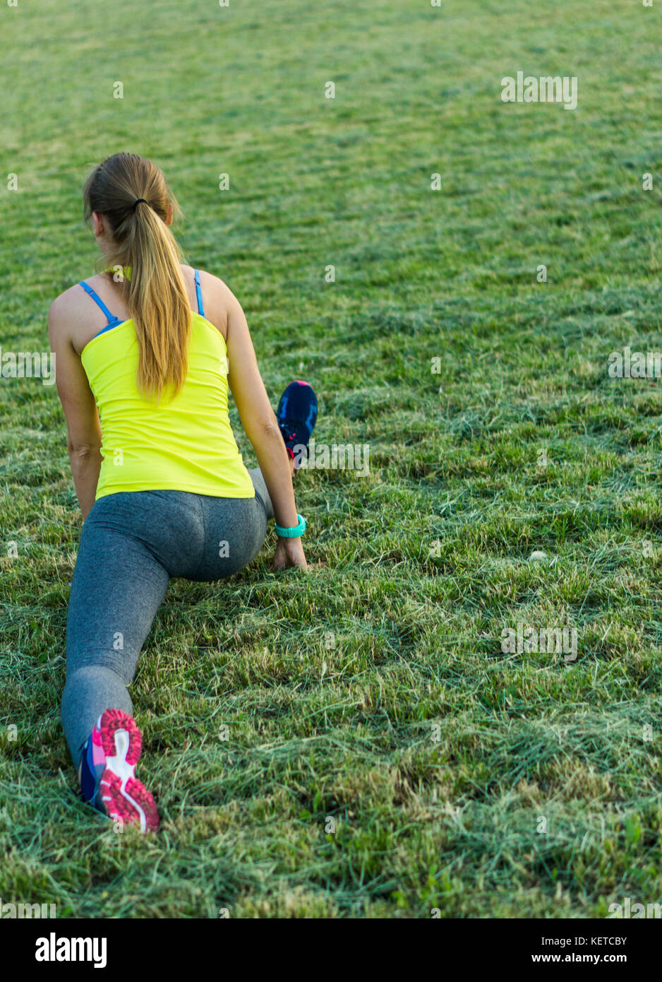 Runner woman stretched twine in stadium exercising outdoors fitness ...