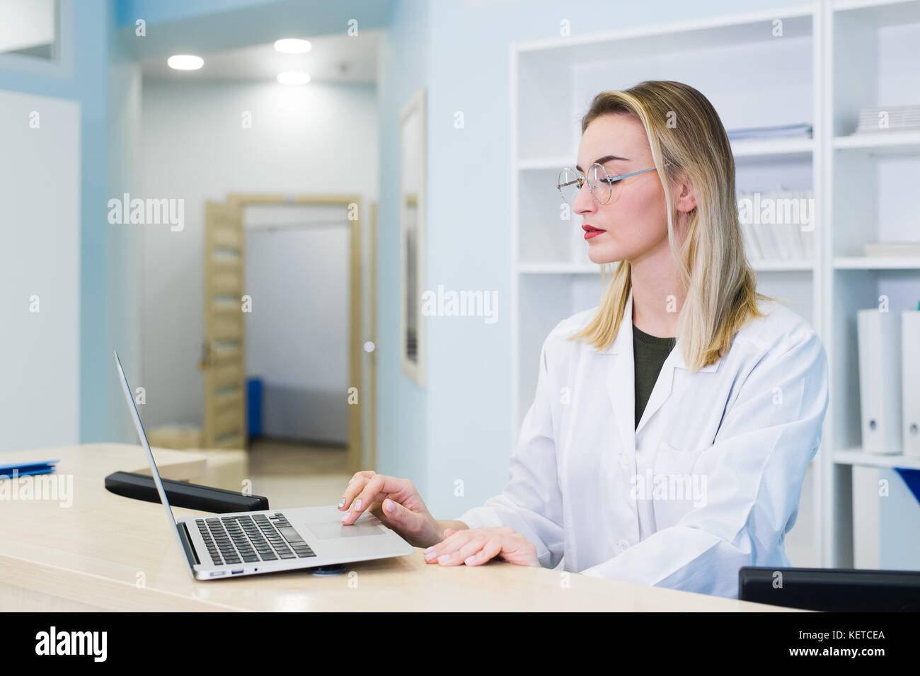 Smiling nurse with laptop scheduling appointment for male patient at ...