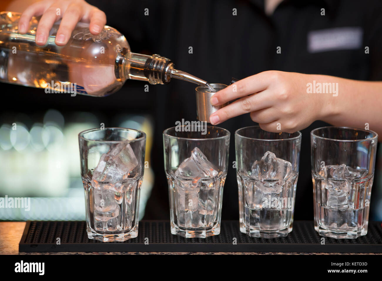 A bartender / bar worker pours shots of spirits in a bar pub Stock ...