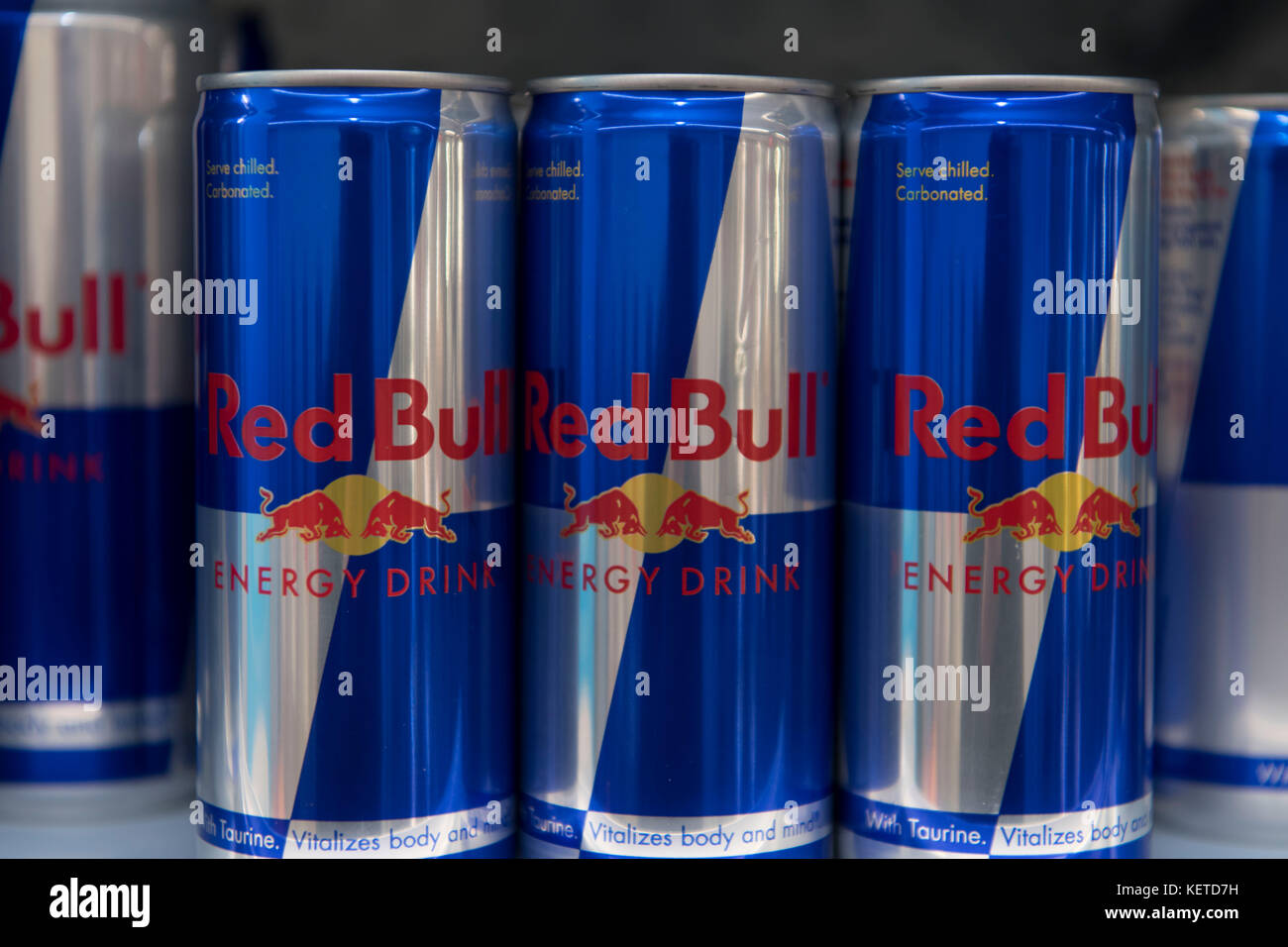 Cans of energy drink Red Bull on display on a supermarket store shelf ...