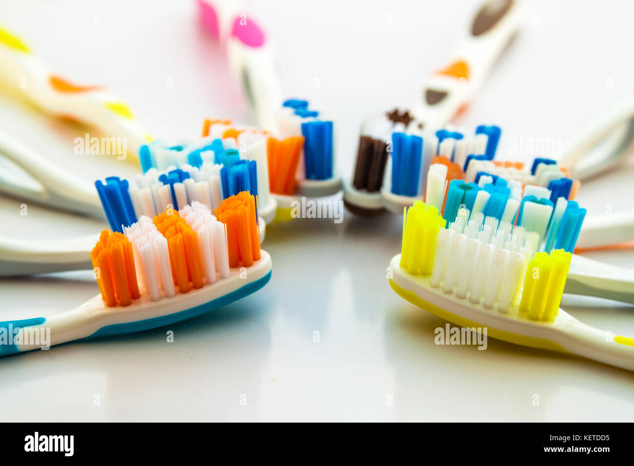 Close up shot of set of multicolored toothbrushes on clean toilet on ...