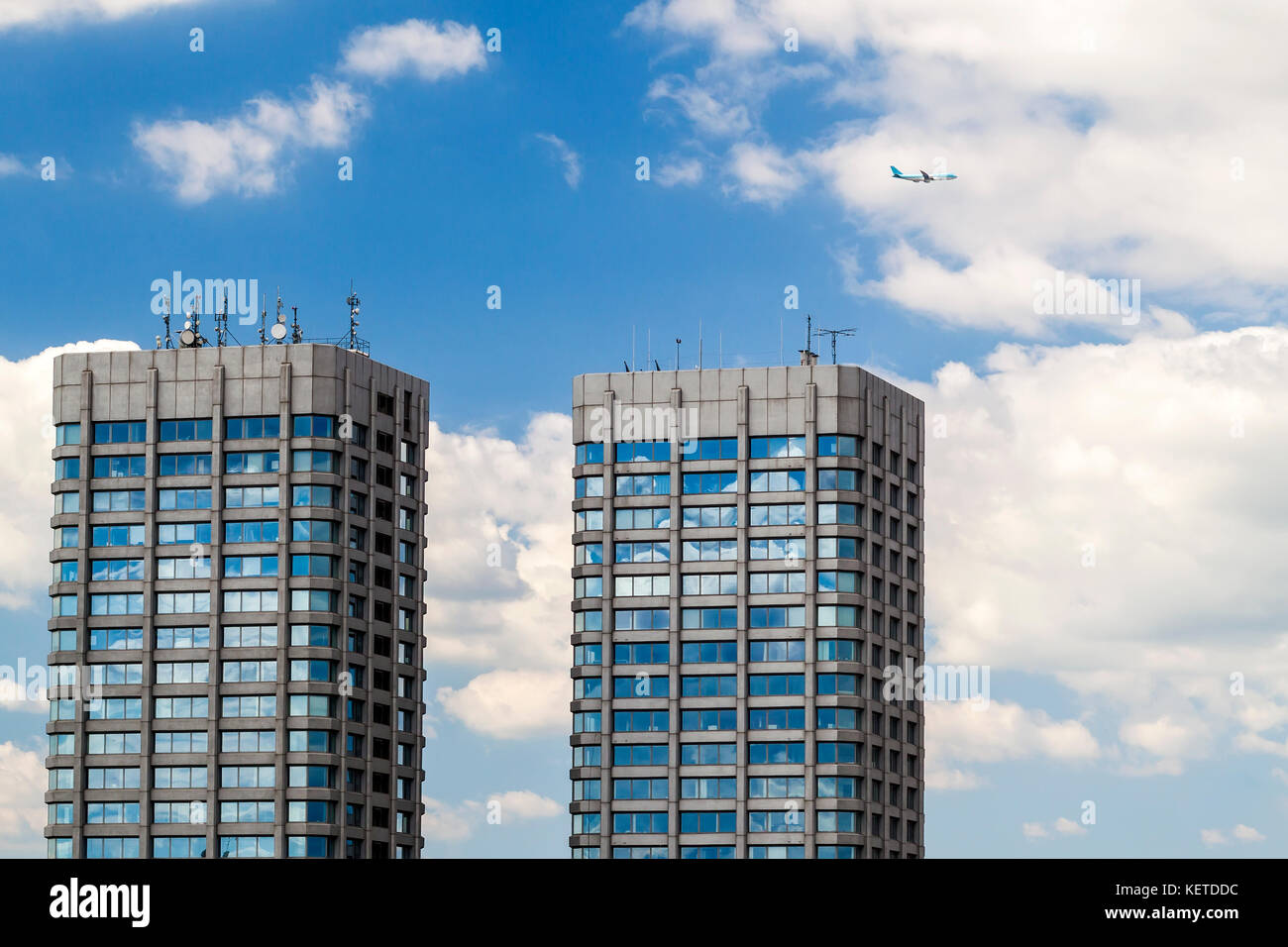 Modern glass and concrete skyscrapers and a plane in the sky Stock ...