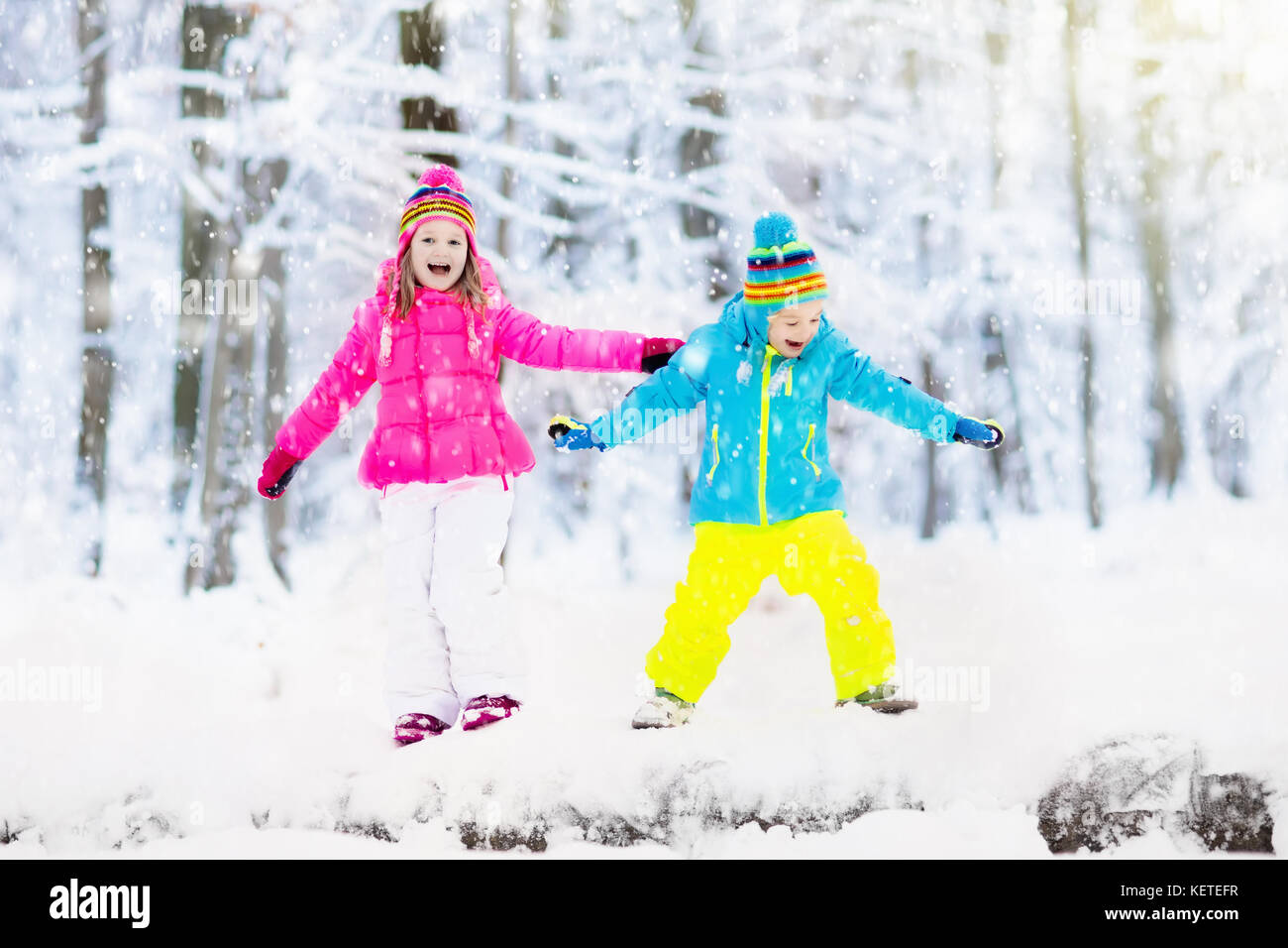 Kids playing in snow. Children play outdoors on snowy winter day. Boy ...