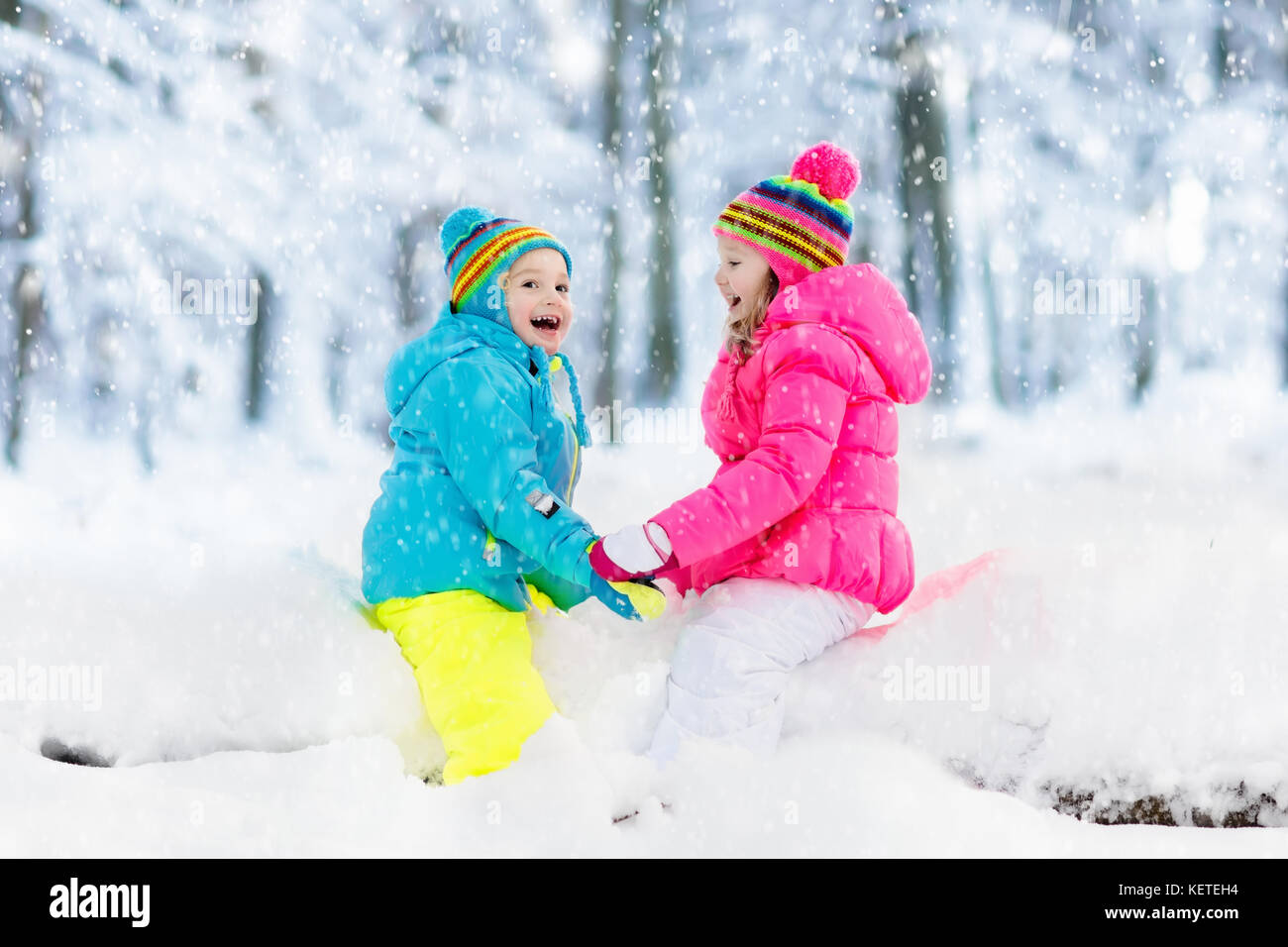 Kids playing in snow. Children play outdoors on snowy winter day. Boy ...