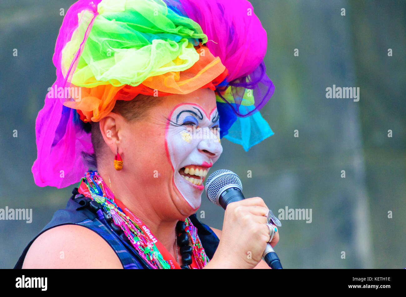 Female performer with a painted face and wearing a colourful headdress ...