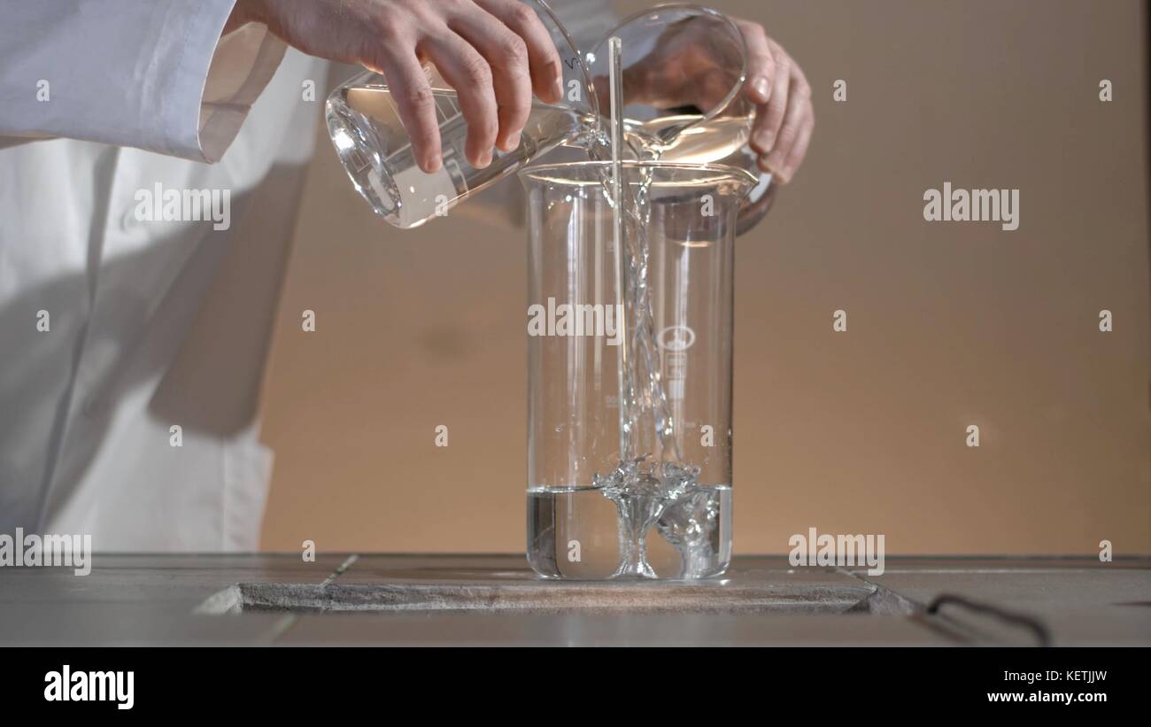 Male researcher carrying out scientific research in a lab. Flasks with ...