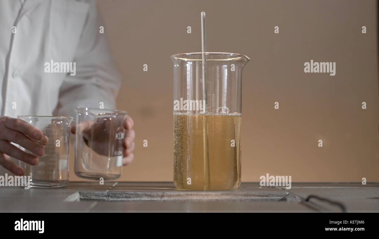 Male researcher carrying out scientific research in a lab. Flasks with ...