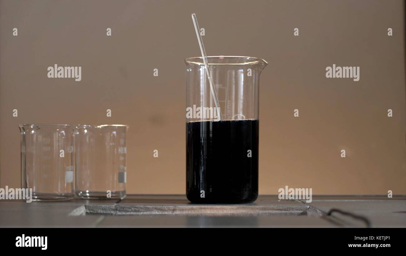 Male researcher carrying out scientific research in a lab. Flasks with ...