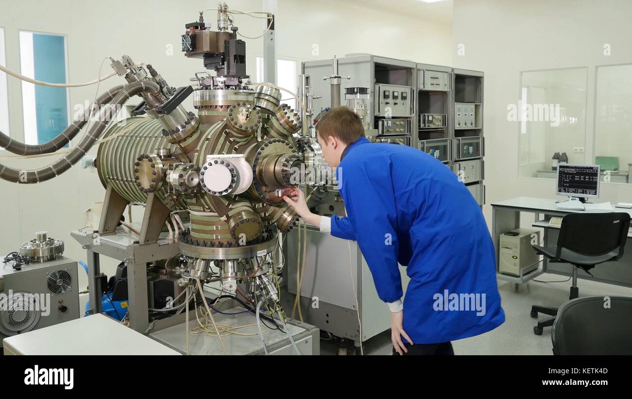 Scientist in a blue protective clothing conducts research in a lab ...