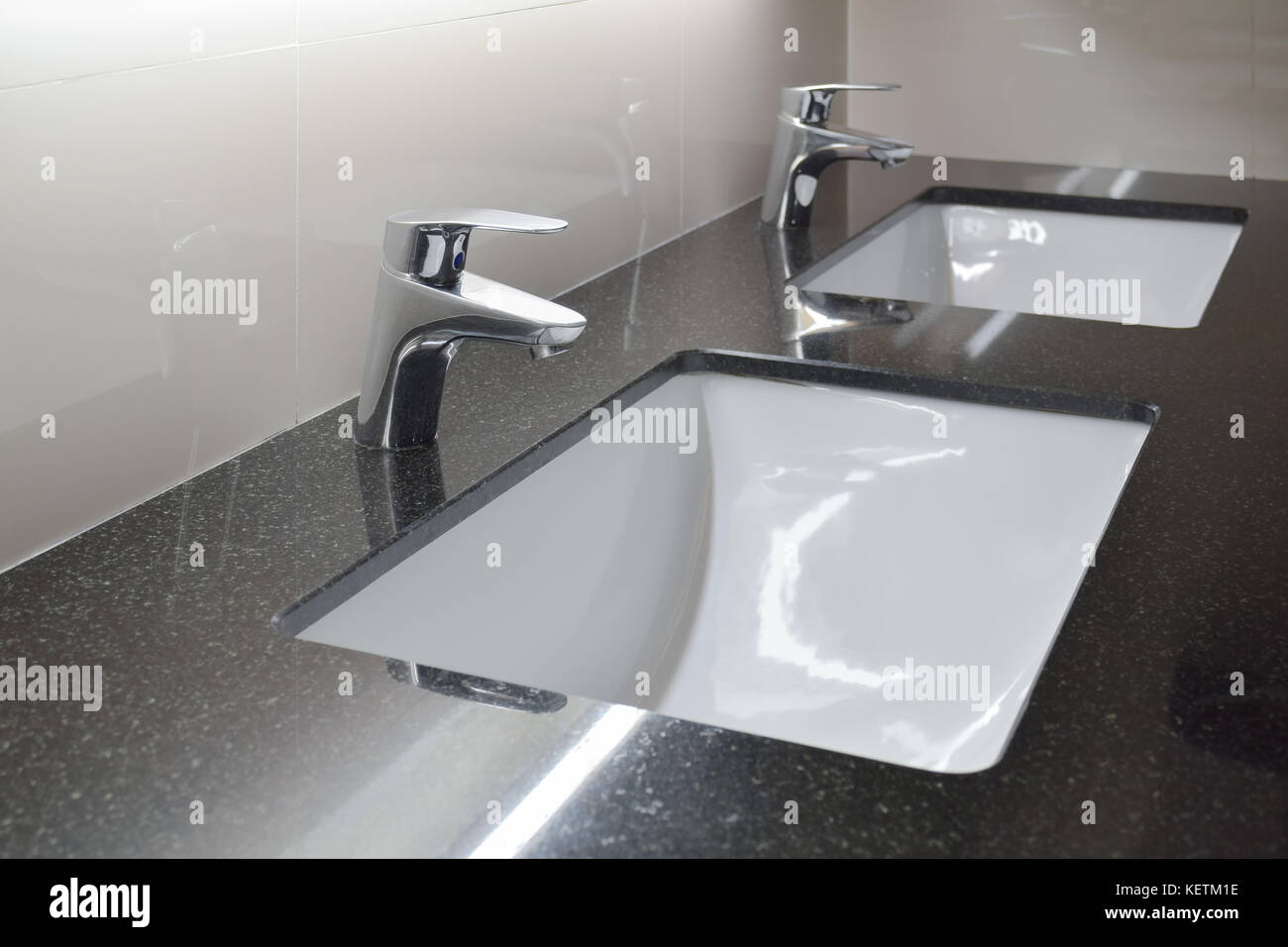 Modern style faucet with black granite counter top Stock Photo - Alamy