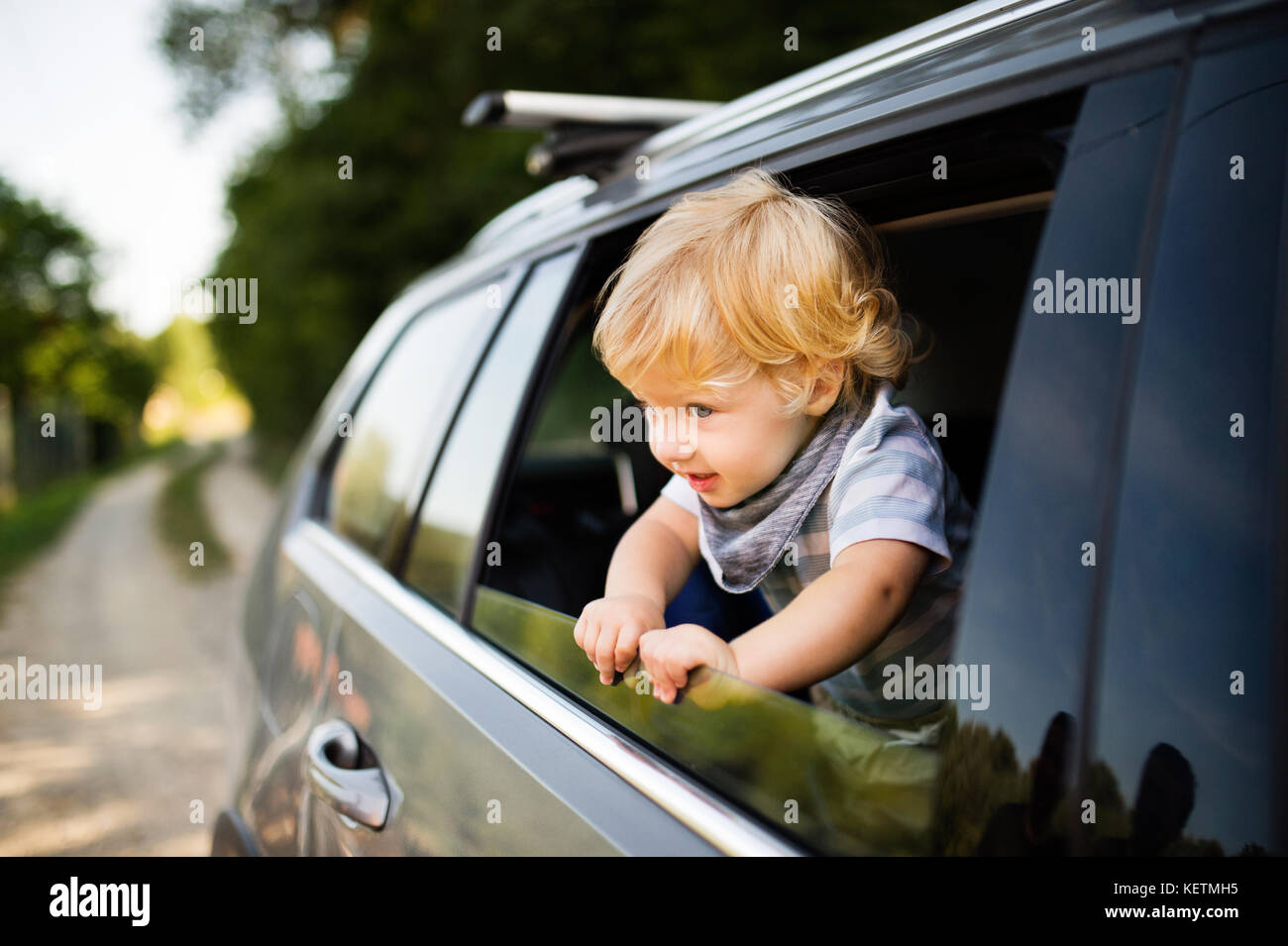 Little boy playing in the car, leaning out of window Stock Photo - Alamy