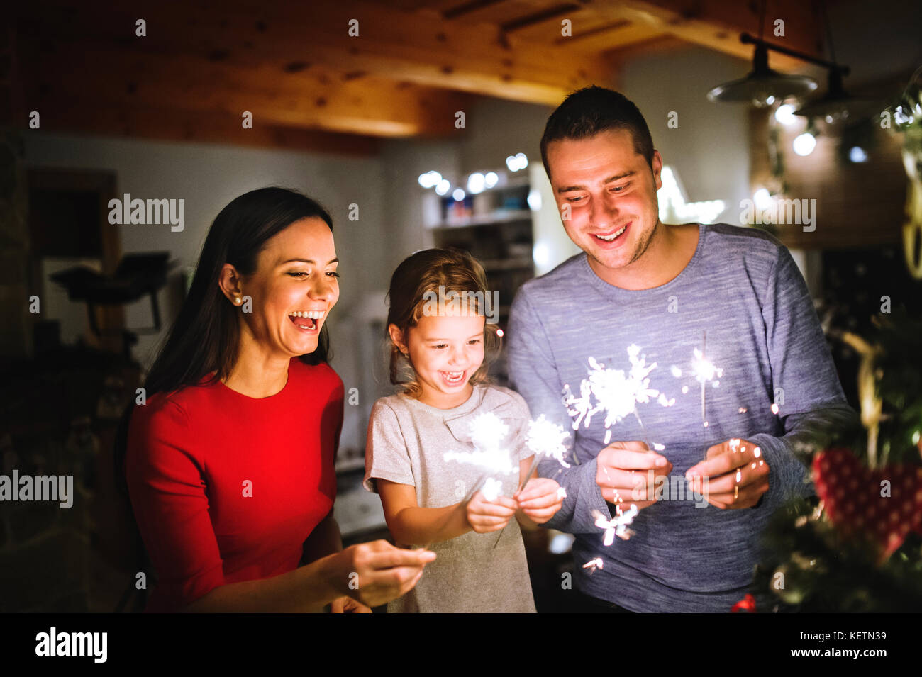 Young family with sparklers at Christmas time at home Stock Photo - Alamy