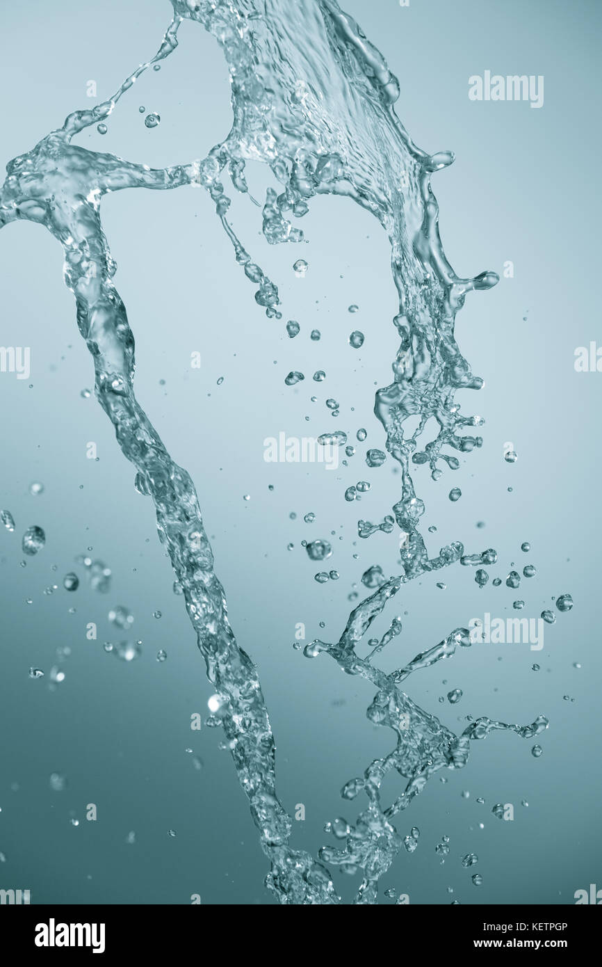 A stream of filtered natural water on a blue background. Splash of ...