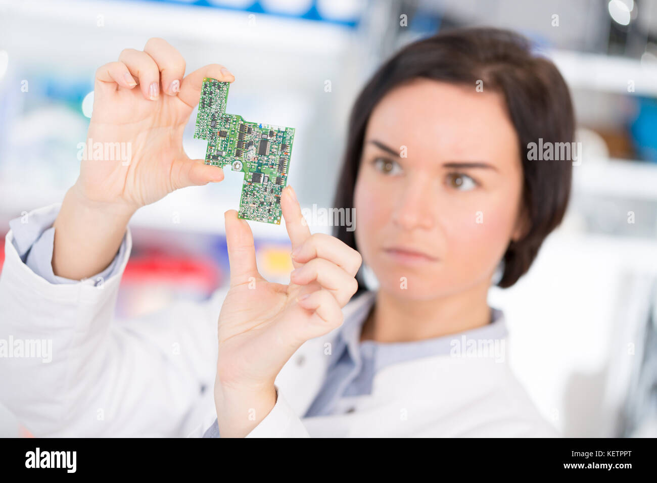 Female laboratory assistant Repairs PCB module for CNC robotics ...