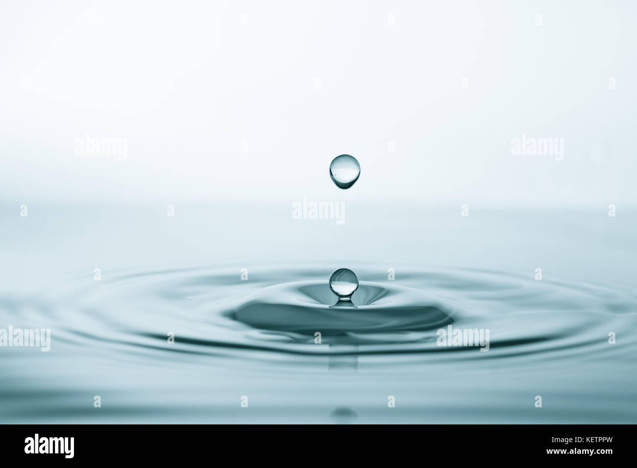 Water drop and splash on water surface on blue background Stock Photo ...