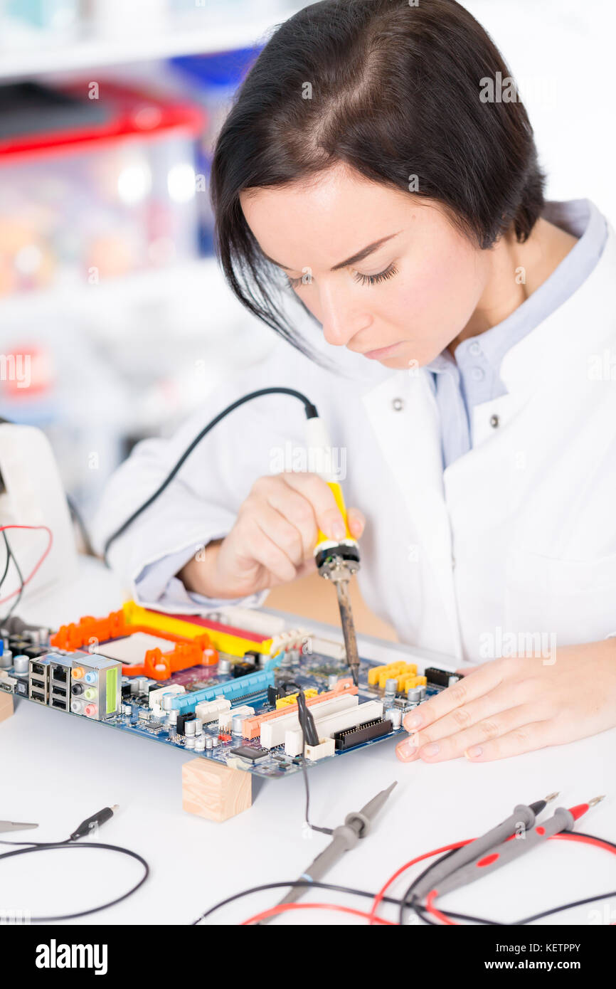 Female laboratory assistant Repairs PCB module for CNC robotics ...