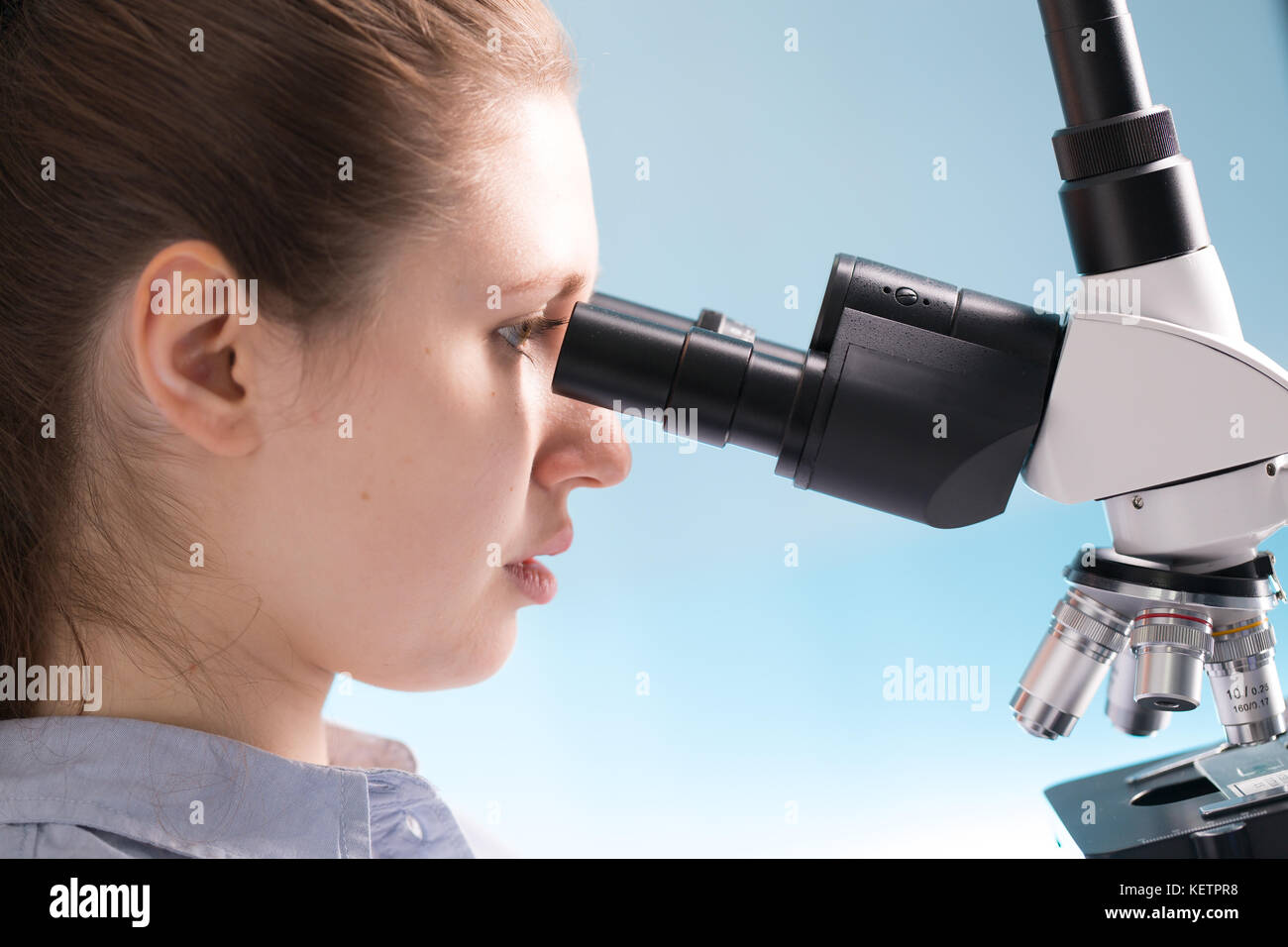 Doctor woman working a microscope. Female scientist looking through a ...